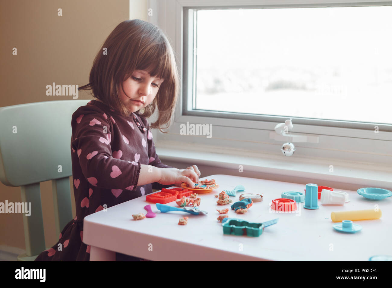 Portrait of cute white Caucasian preschooler girl playing plasticine ...