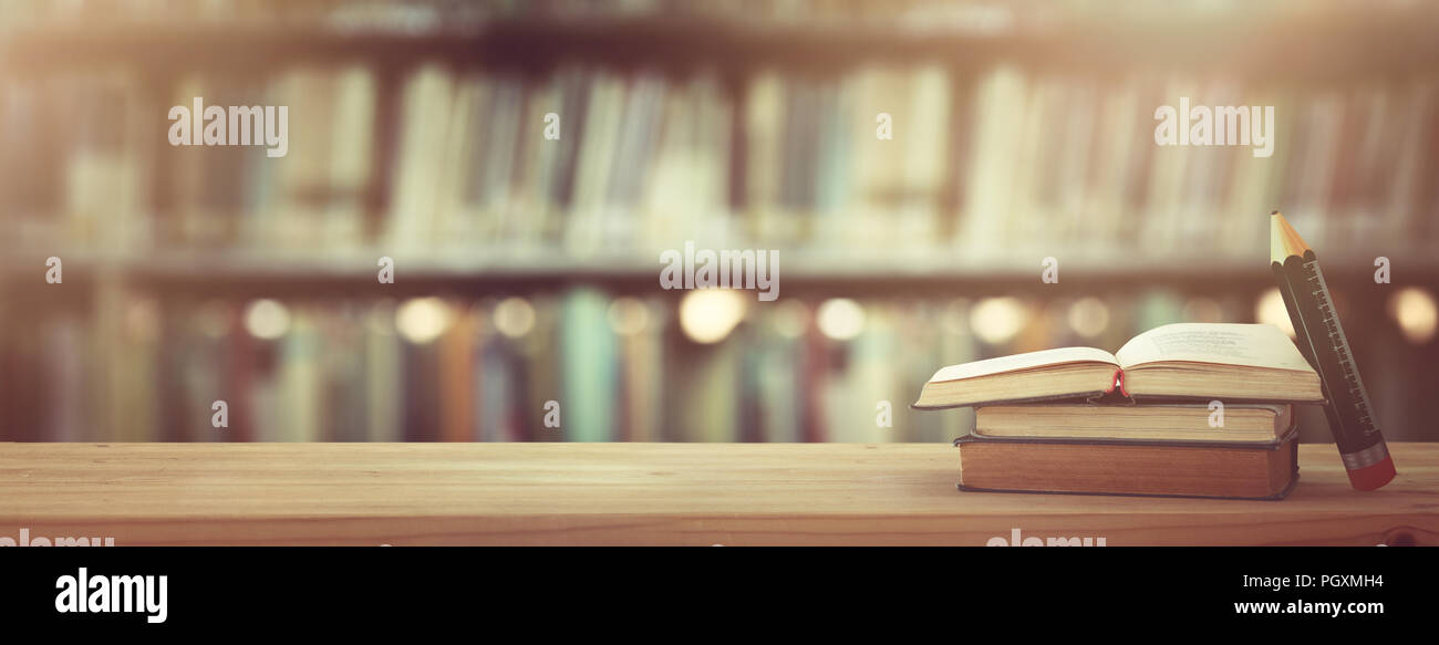 back to school concept. stack of books over wooden desk in front of ...