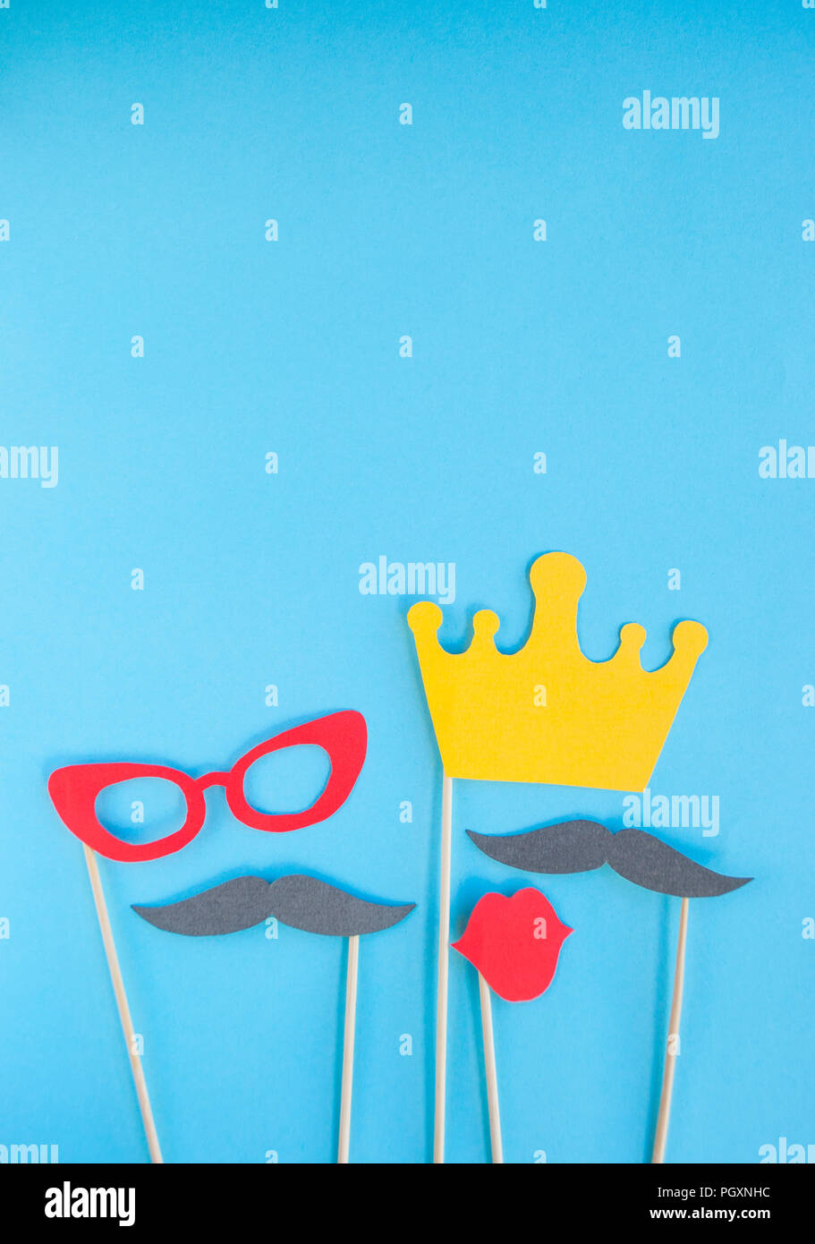 Colorful photo booth props glasses, lips, crown and moustaches on blue ...