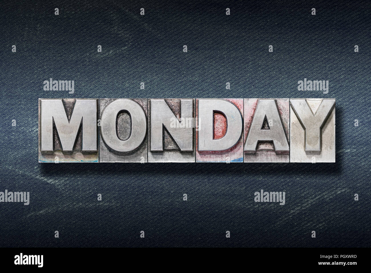 Monday word made from metallic letterpress on dark jeans background ...