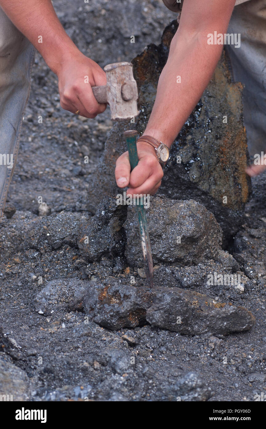 A tourist digging for fun in one of the basins of the former excavation ...