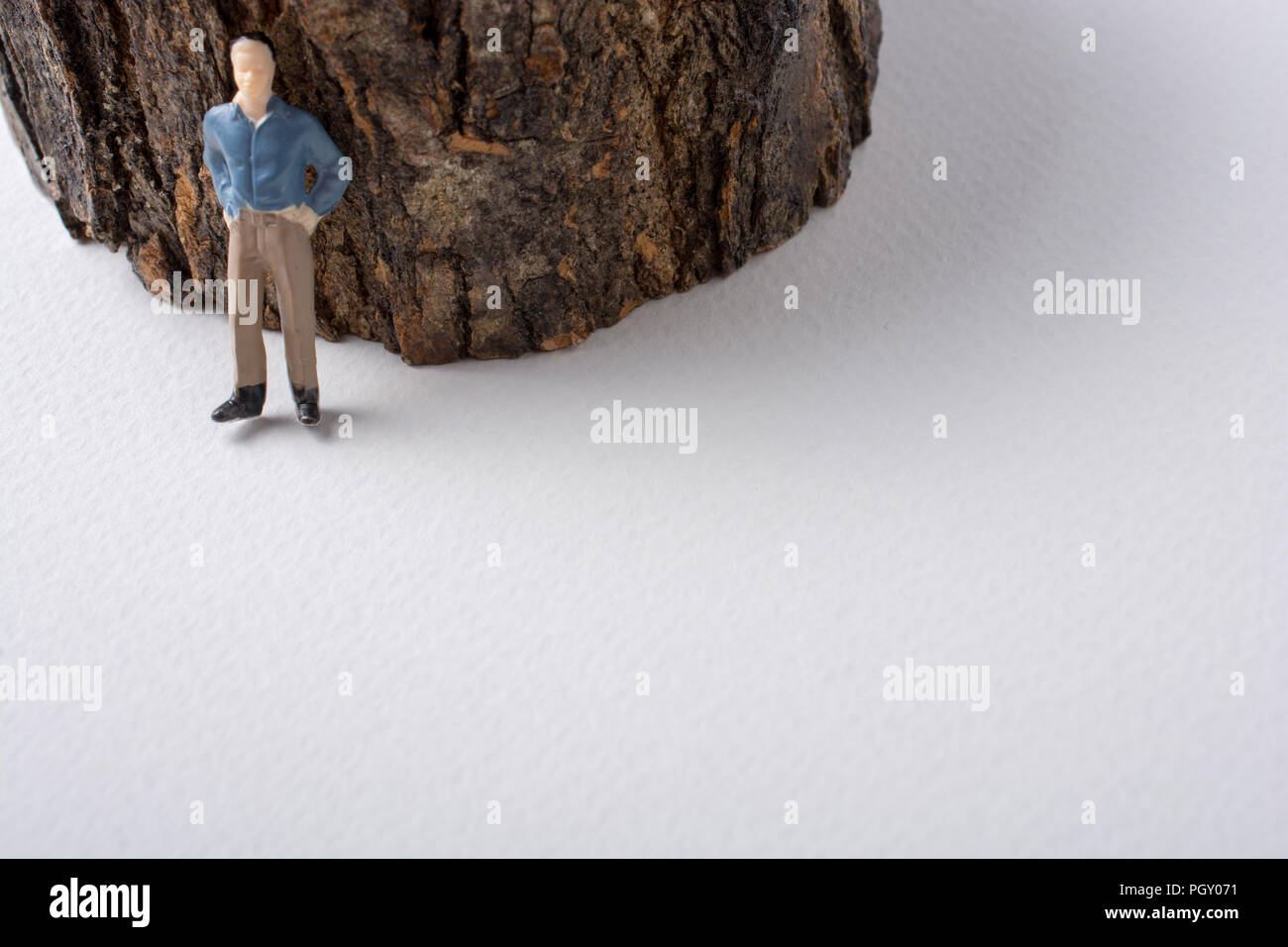 Tiny figurine of men model beside a tree trunk Stock Photo - Alamy