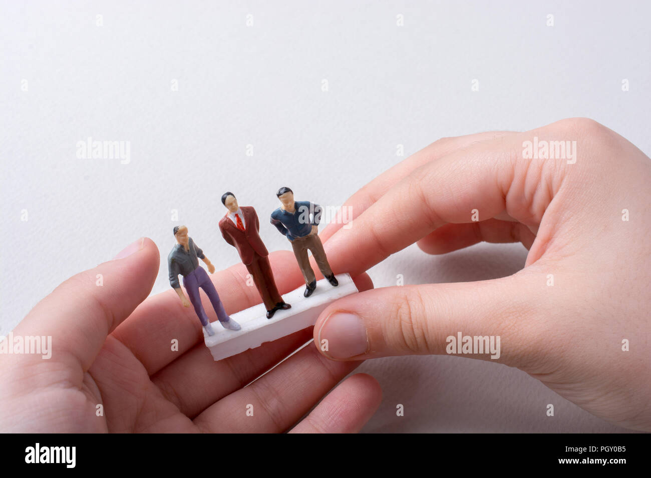 Tiny figurines of men miniature model in hand Stock Photo - Alamy