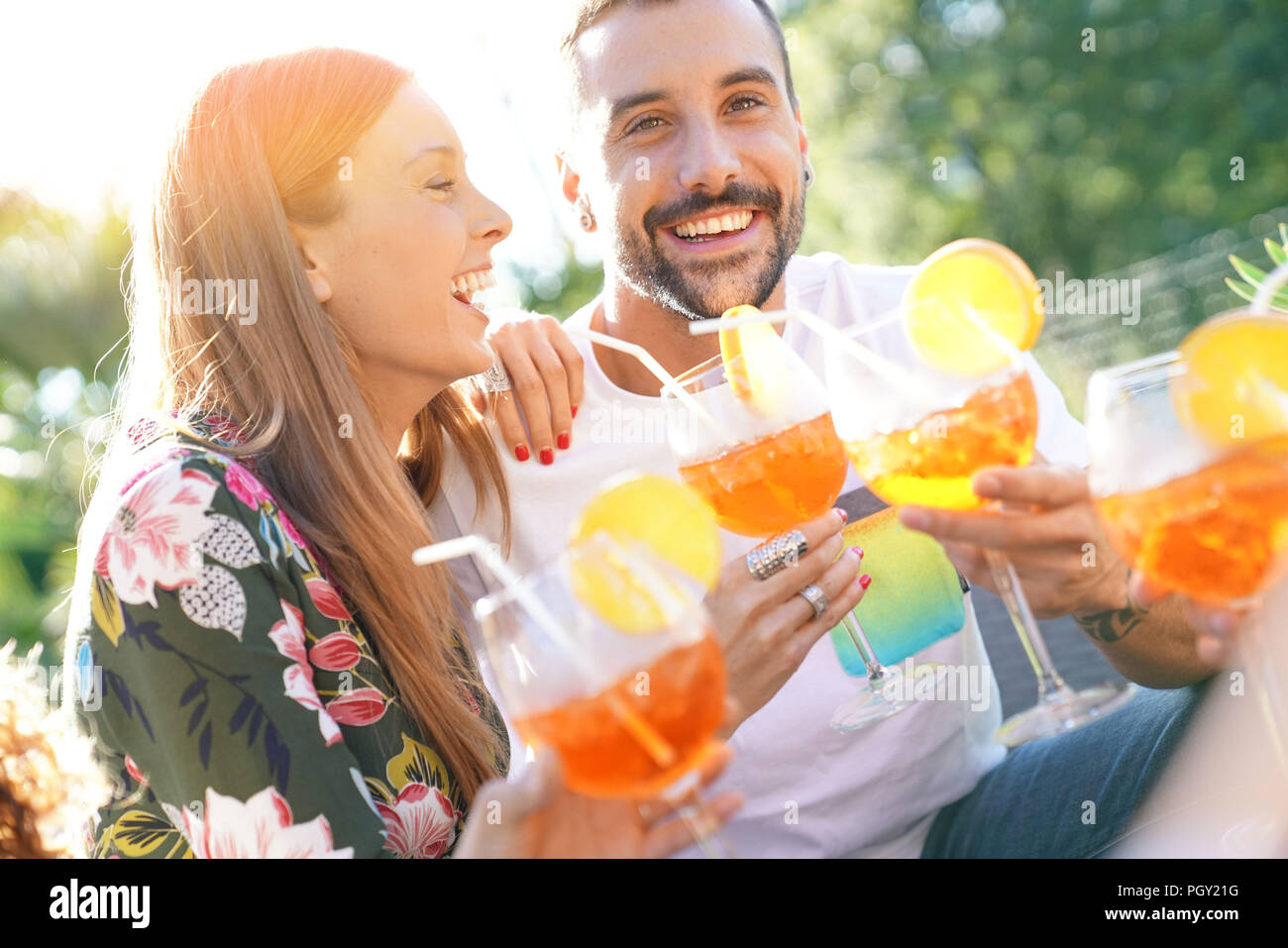 Cheerful couple having fun cheering with cocktails Stock Photo - Alamy