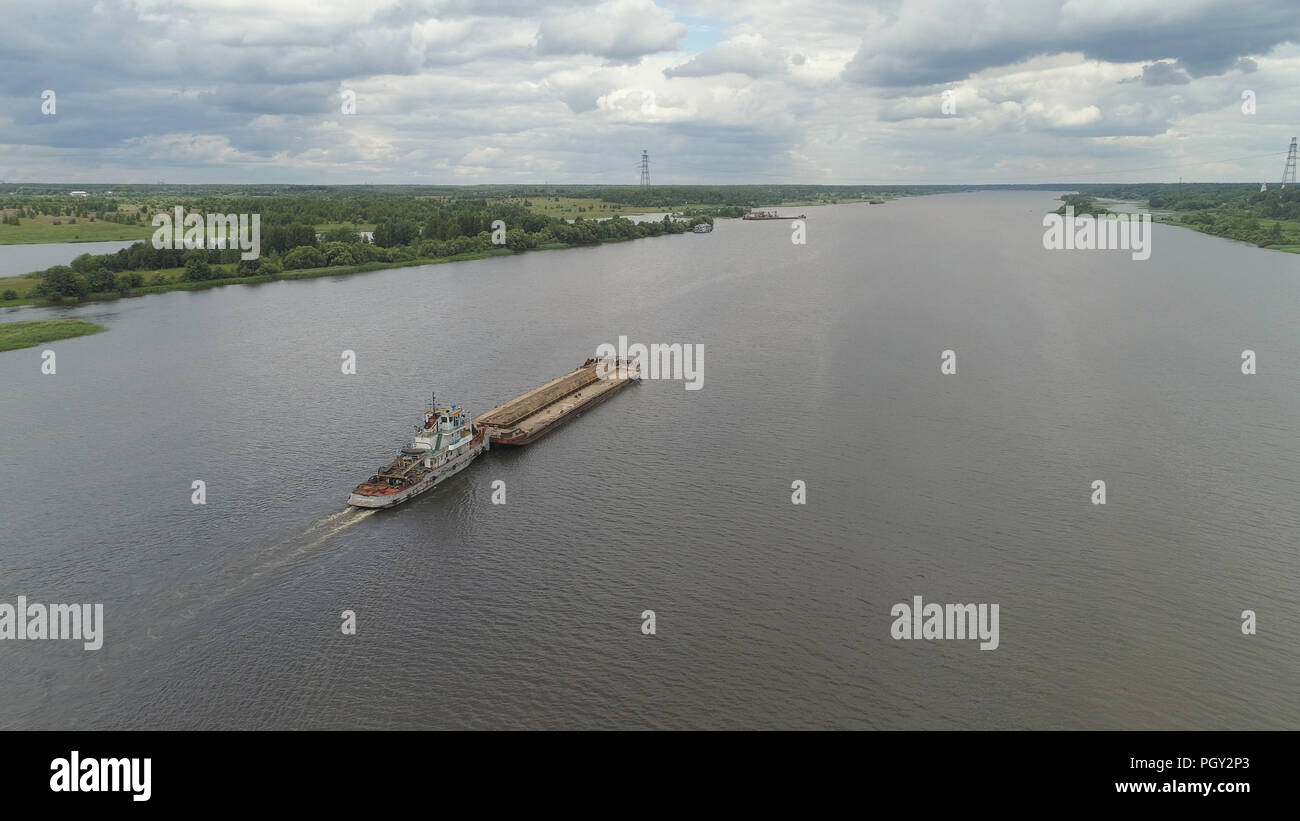 Aerial view:Barge with cargo on the river Volga. River tugboat moves ...