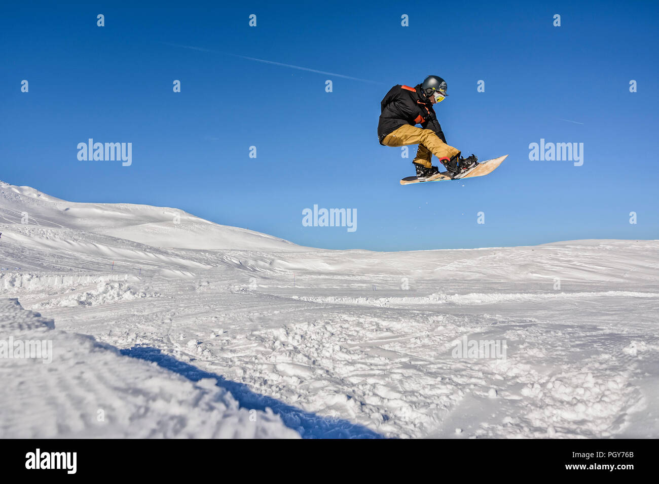A freestyle snowboarder makes a mute grab Stock Photo - Alamy