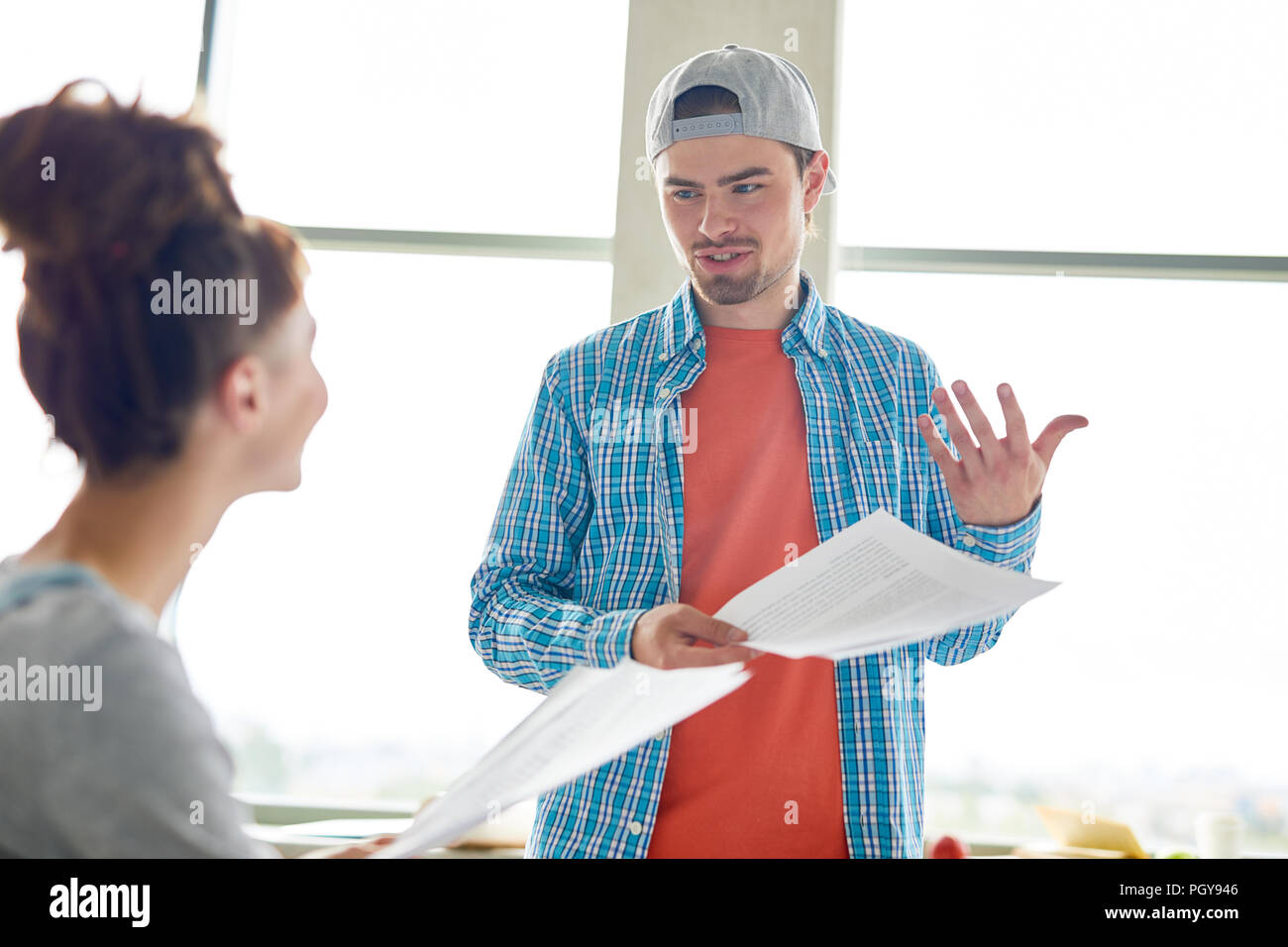 Positive students discussing papers at class: confident handsome young ...