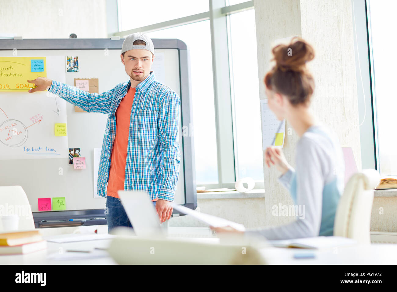 Confident handsome young guy with beard standing at whiteboard with ...