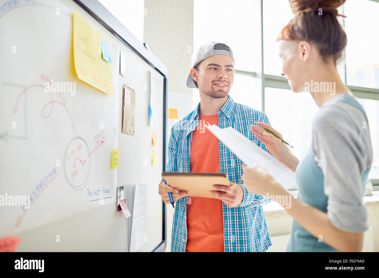 Cheerful creative young students in casual clothing standing at ...