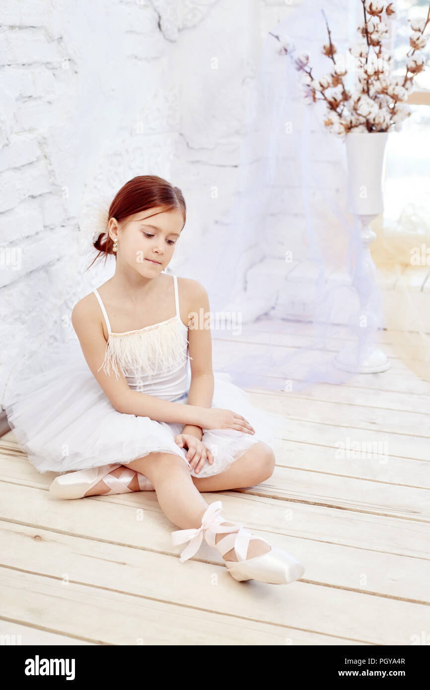 Little prima ballet. Young ballerina girl is preparing for a ballet ...
