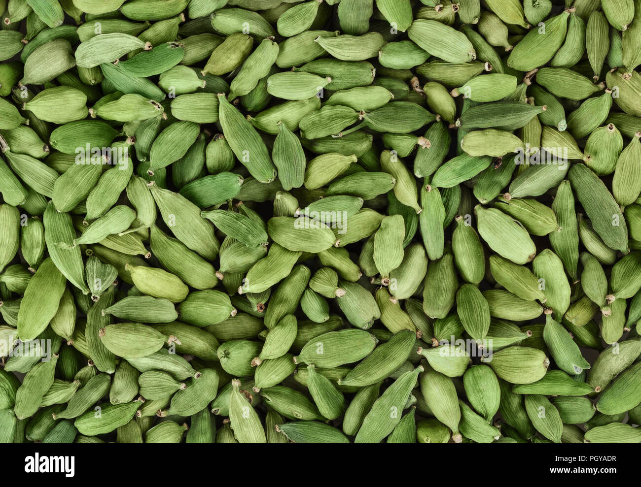 Dry green cardamom background Stock Photo - Alamy