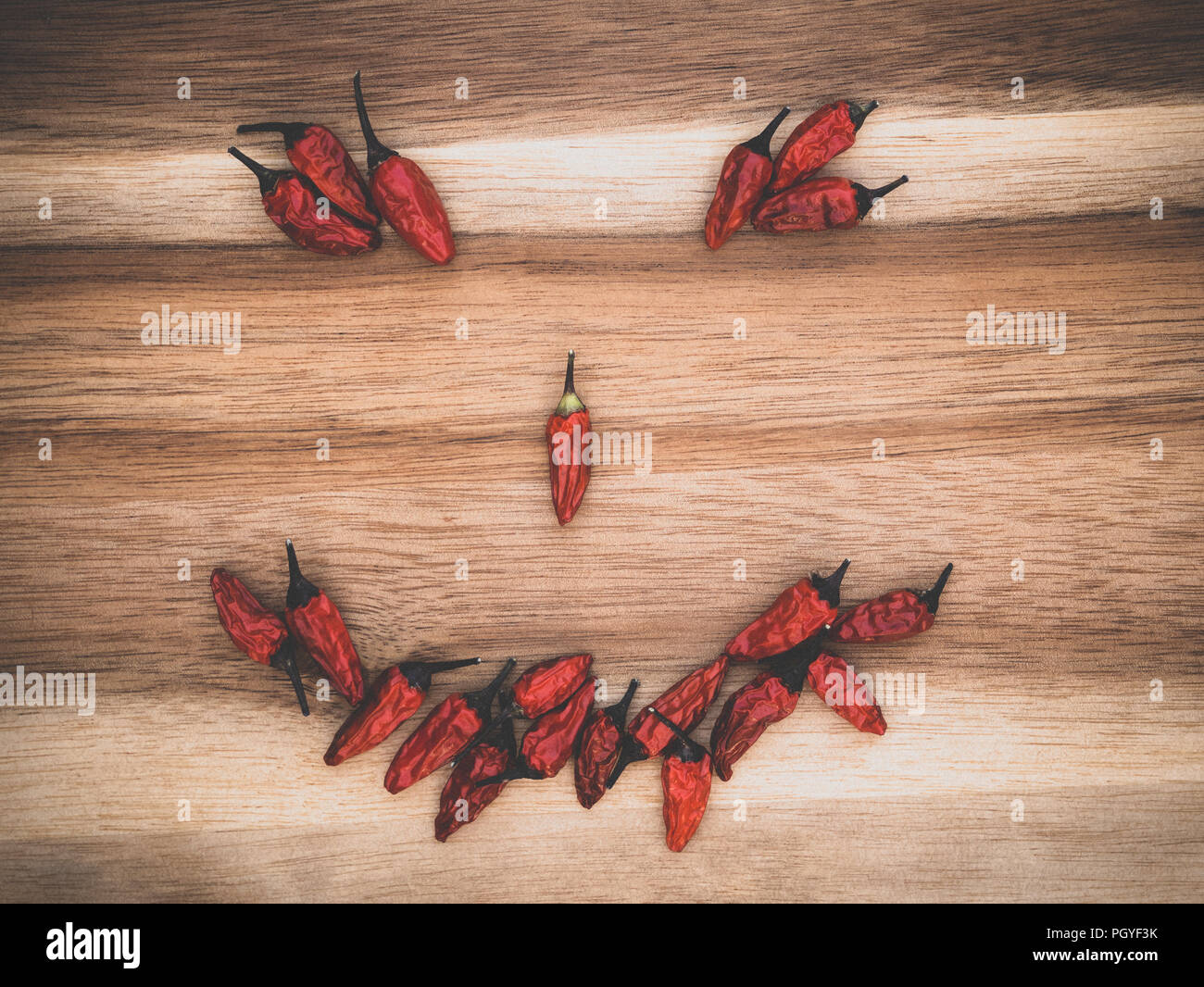 Chilies in the shape of a scary halloween face on wooden board Stock ...