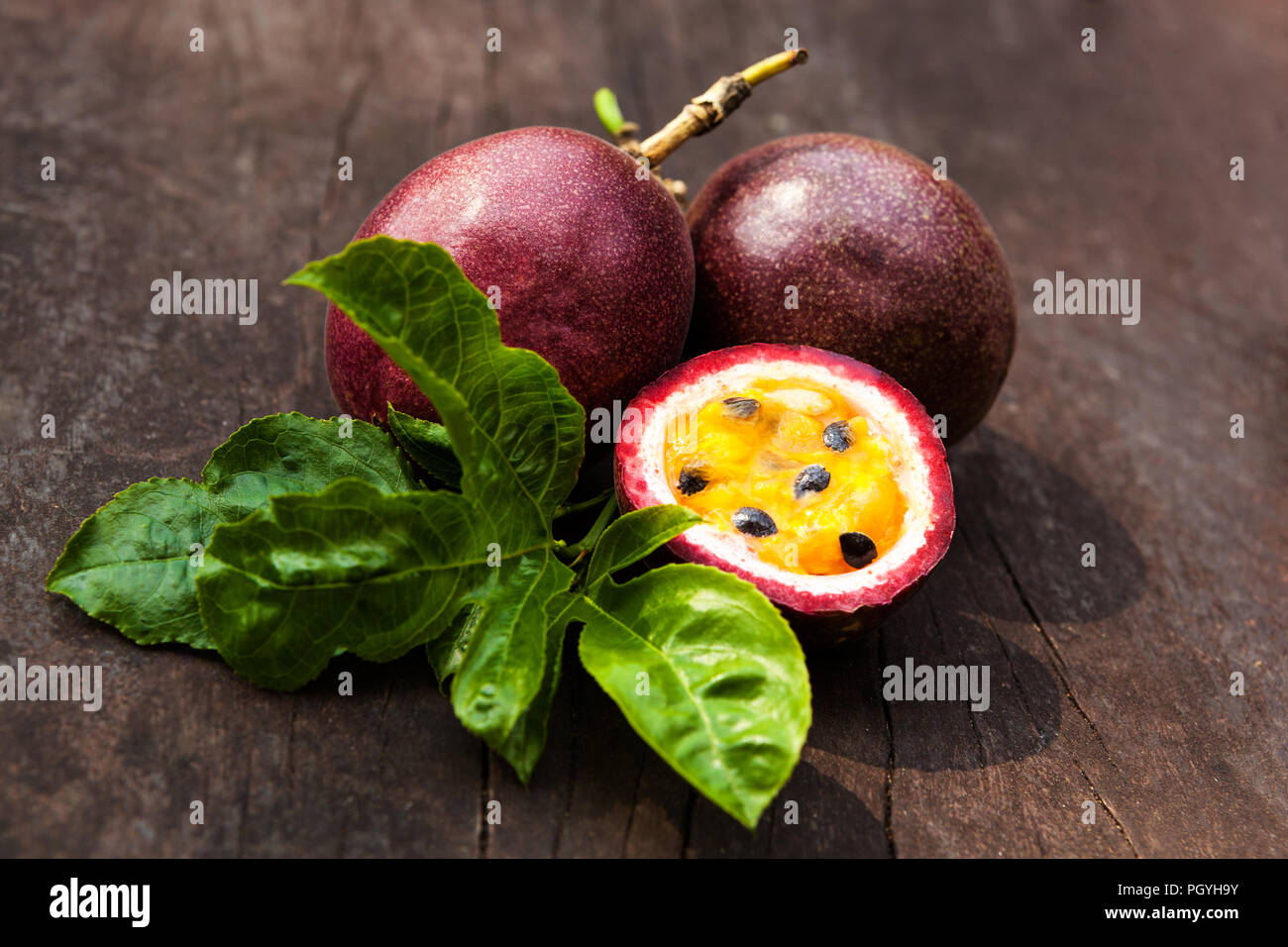 Purple passion fruit with leaves on wooden table. Passiflora edulis ...