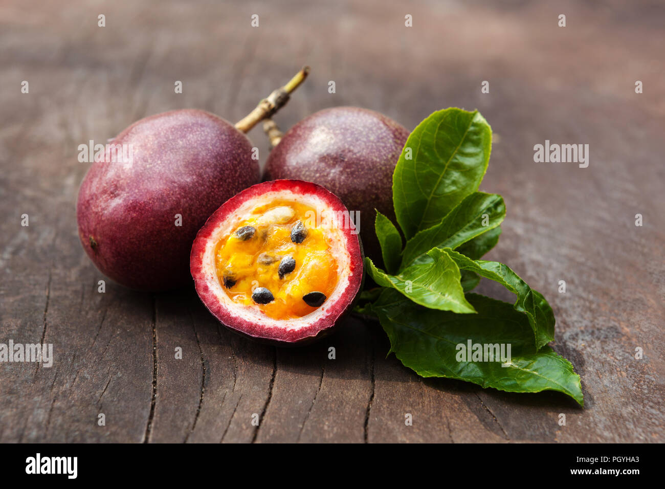 Whole and cut passionfruit on wooden table Stock Photo - Alamy