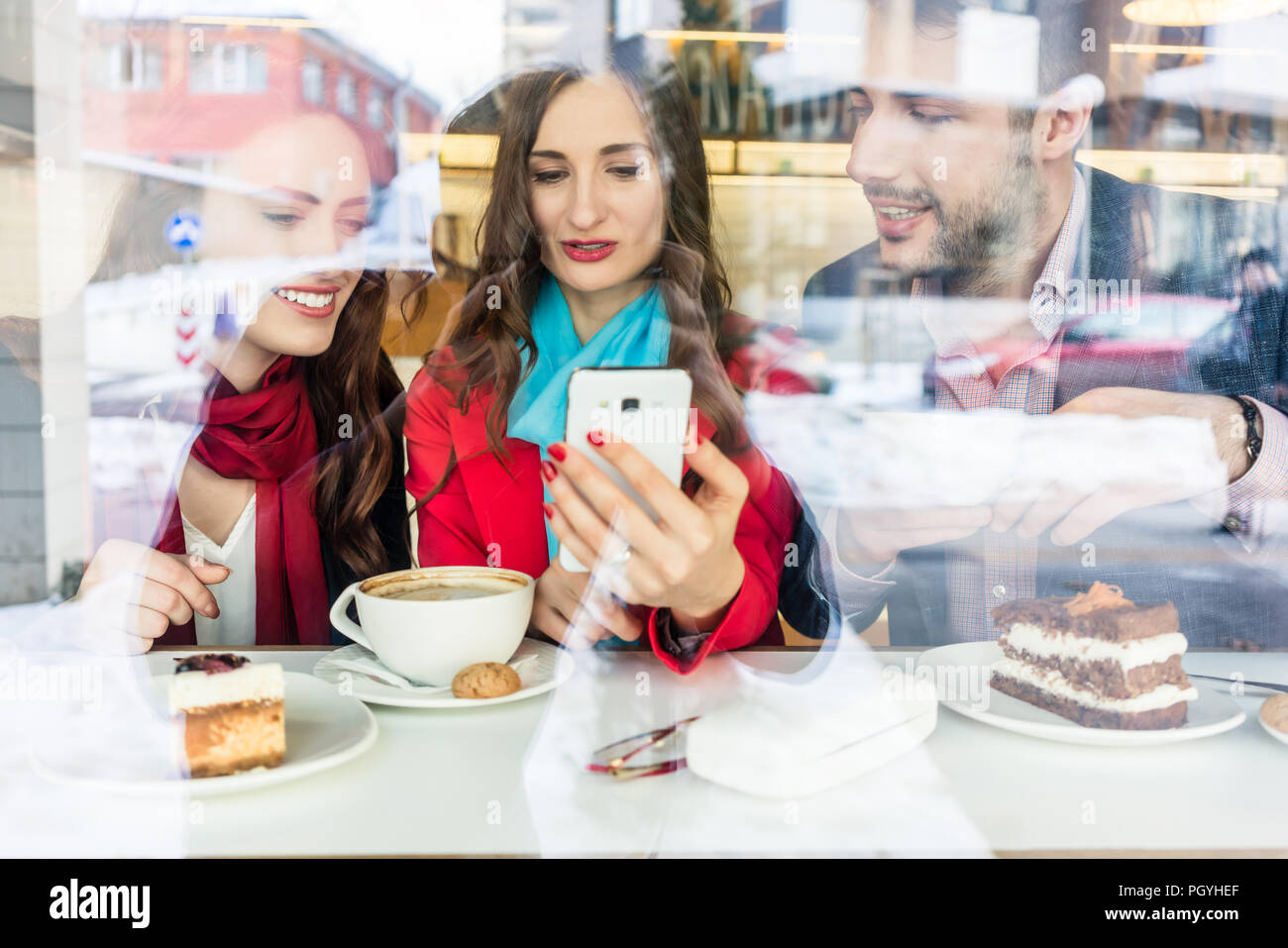 Fashionable young woman showing to her best friends pictures or videos ...