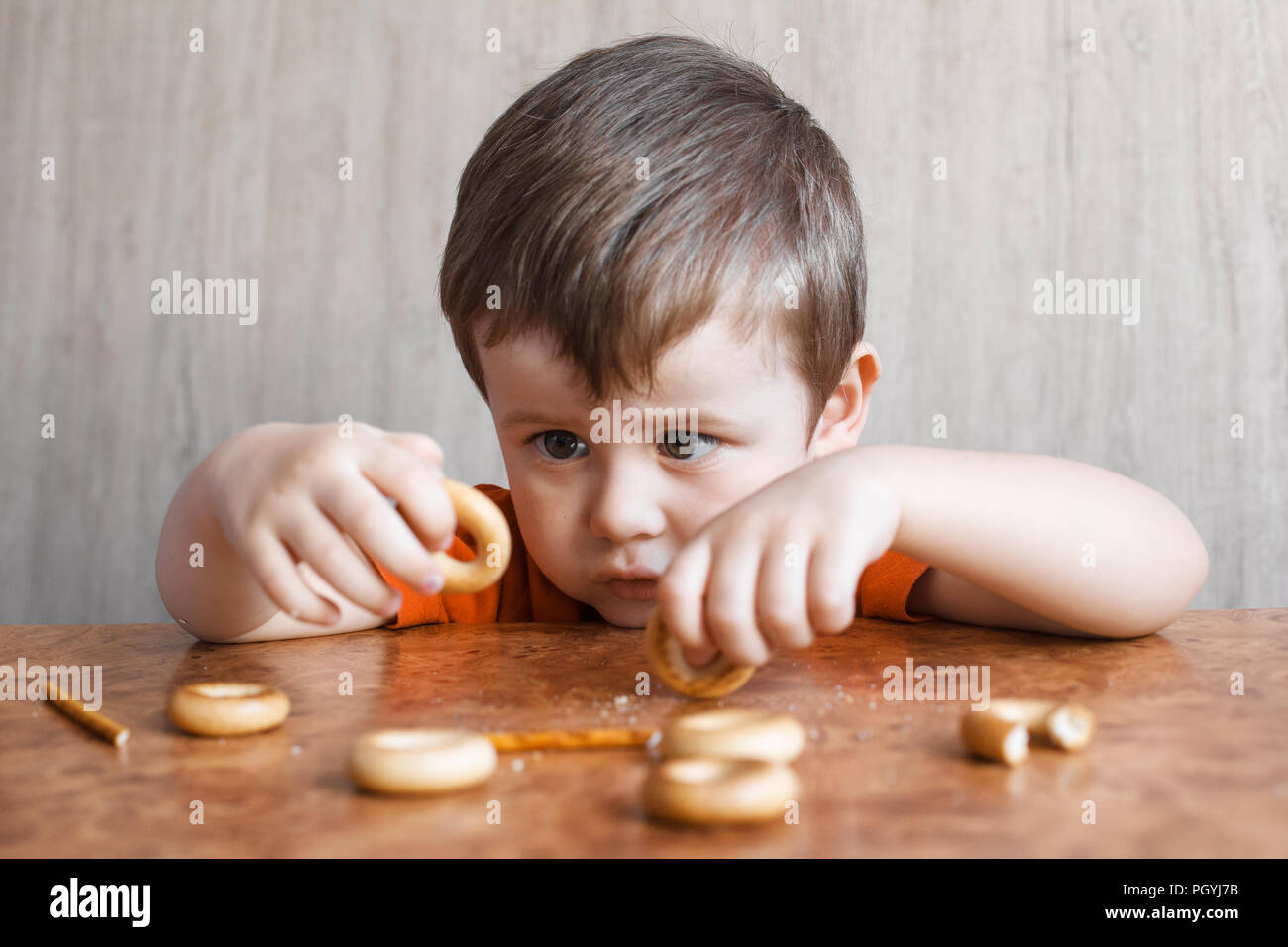 Cute little boy is playing with Bagel Stock Photo - Alamy
