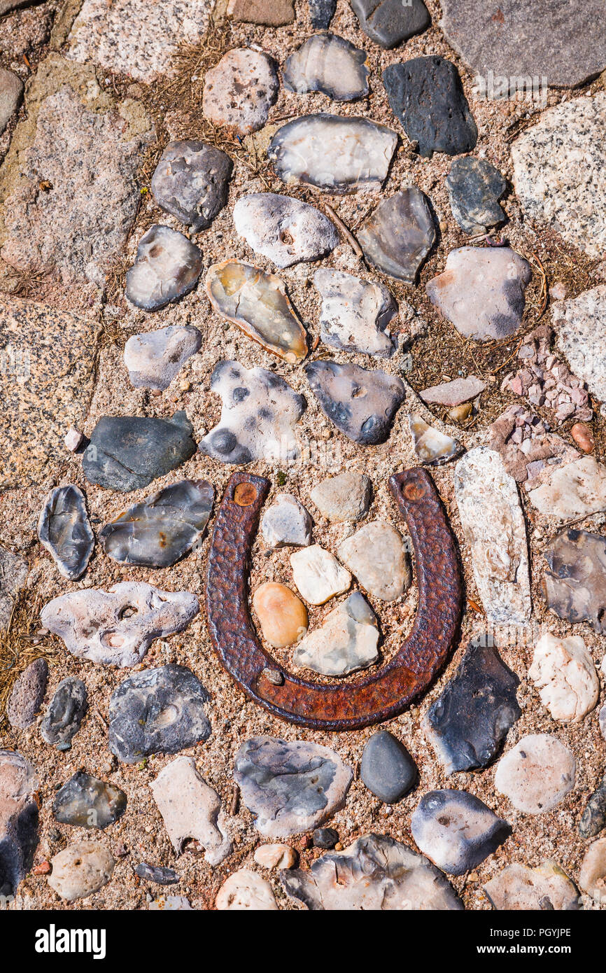 Old metal horse-shoe embedded in stone path surface, a reminder that a ...