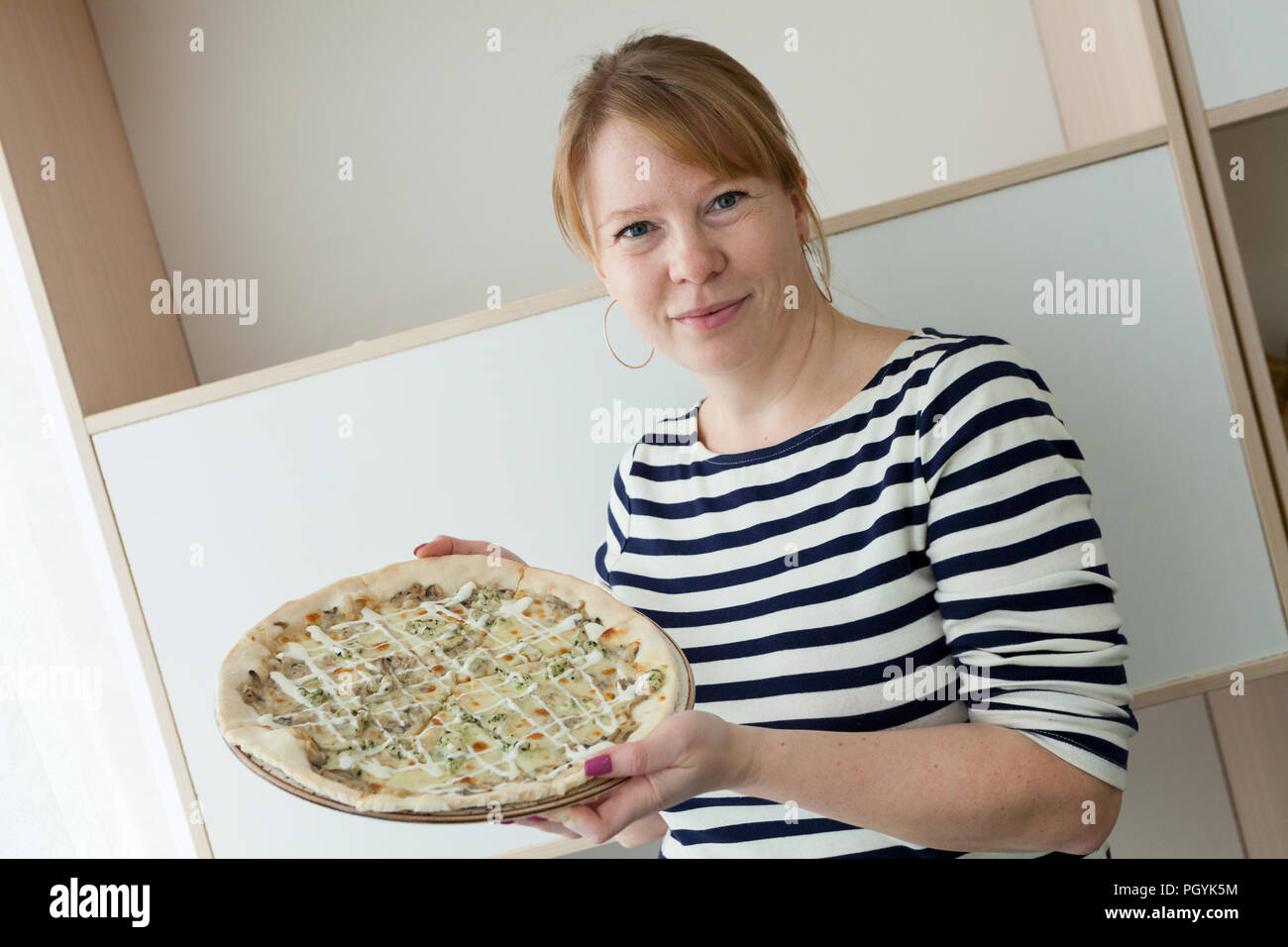 Happy smiling Caucasian woman holding pizza on plate Stock Photo - Alamy