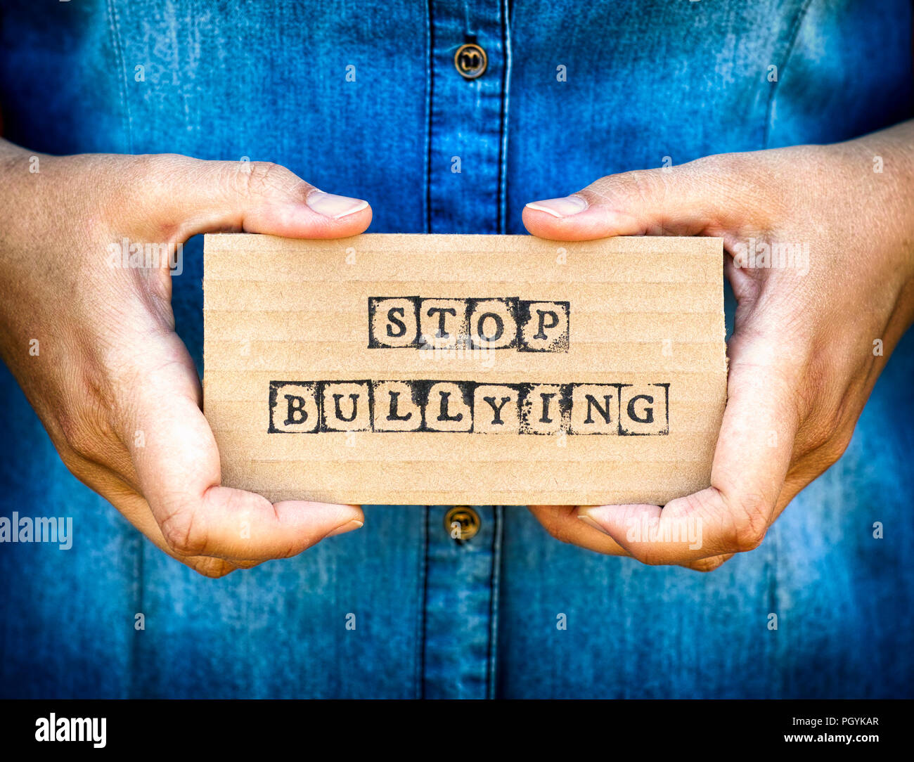 Woman hand holding cardboard card with words Stop Bullying made by ...