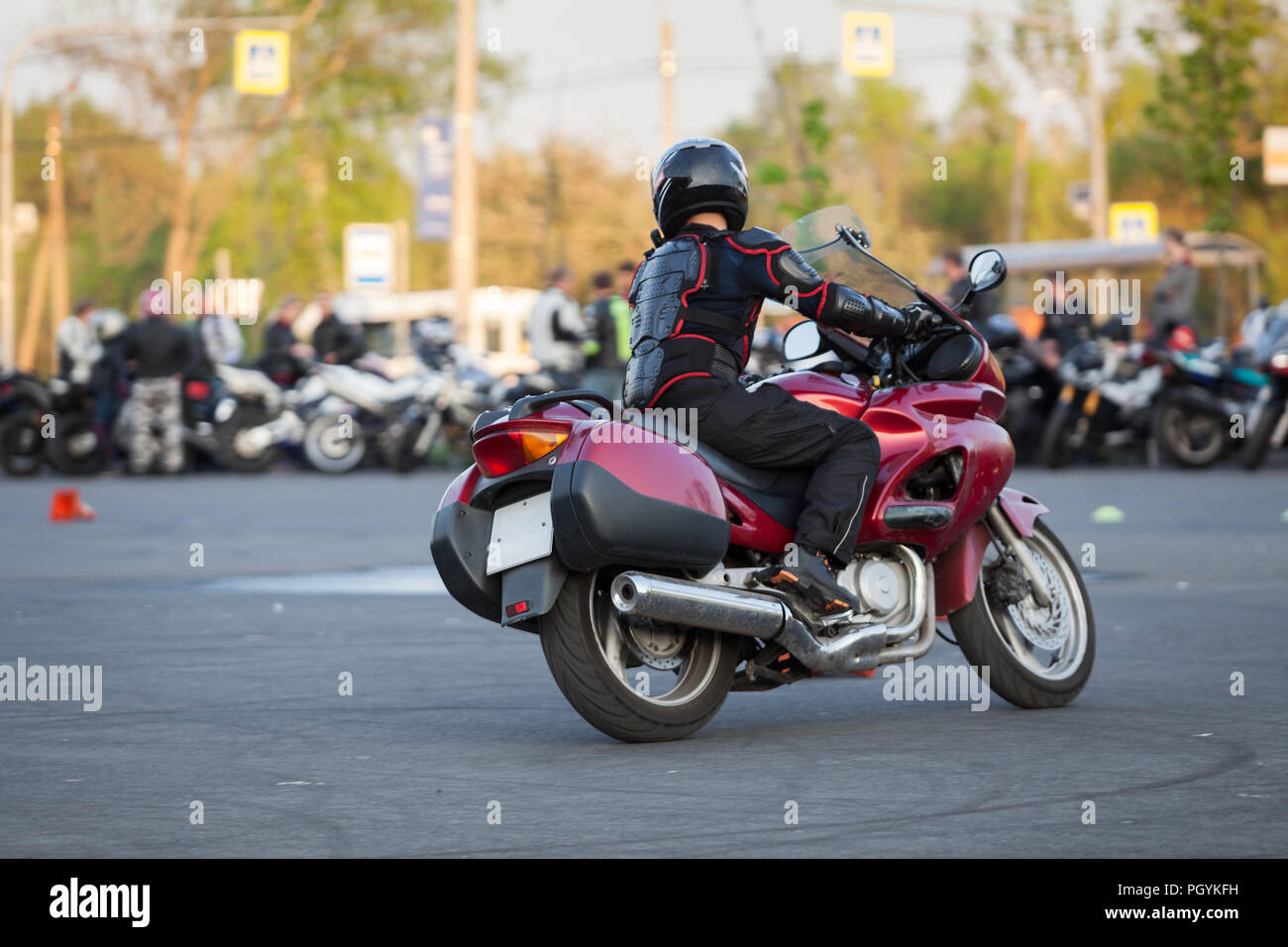 Caucasian man driving on red motorcycle on urban asphalt square, skill ...