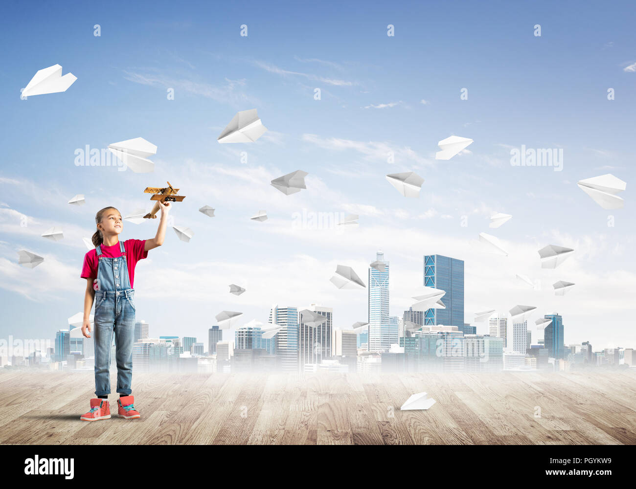 Cute kid girl stand on wooden floor and paper planes flying around ...