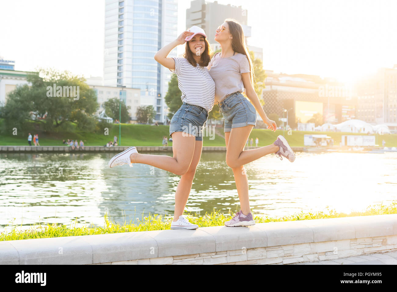 Two young women hugging and laughing at sunset in the city. Best ...