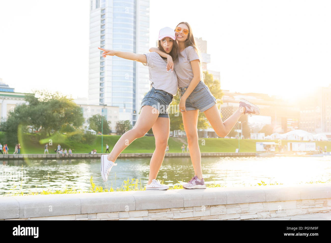 Two young women hugging and laughing at sunset in the city. Best ...