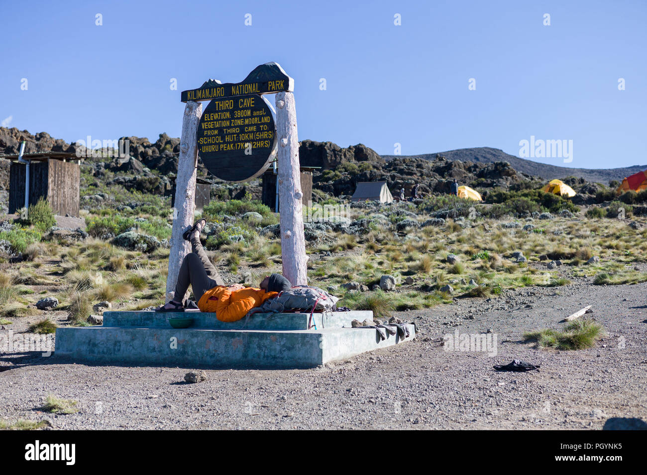 Hiker resting at sign for Third Cave Camp, Rongai Route, Mount ...