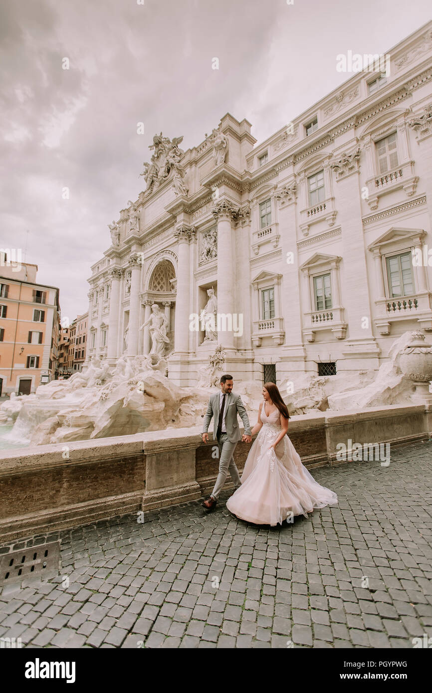 Just married bride and groom posing in front of Trevi Fountain (Fontana ...