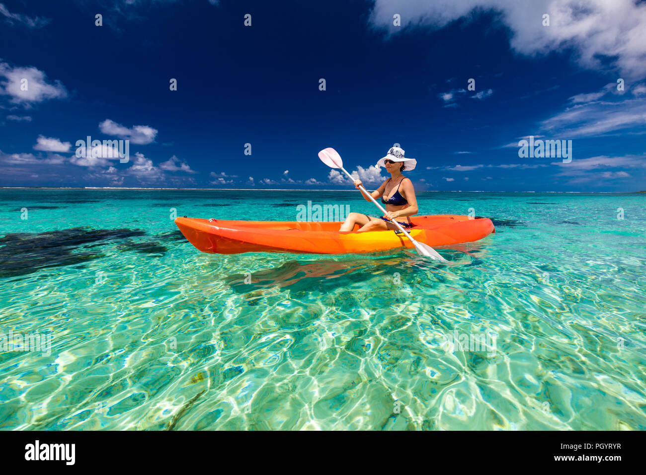 Woman in white hat Kayaking in the lagoon of tropical Samoa Islands ...