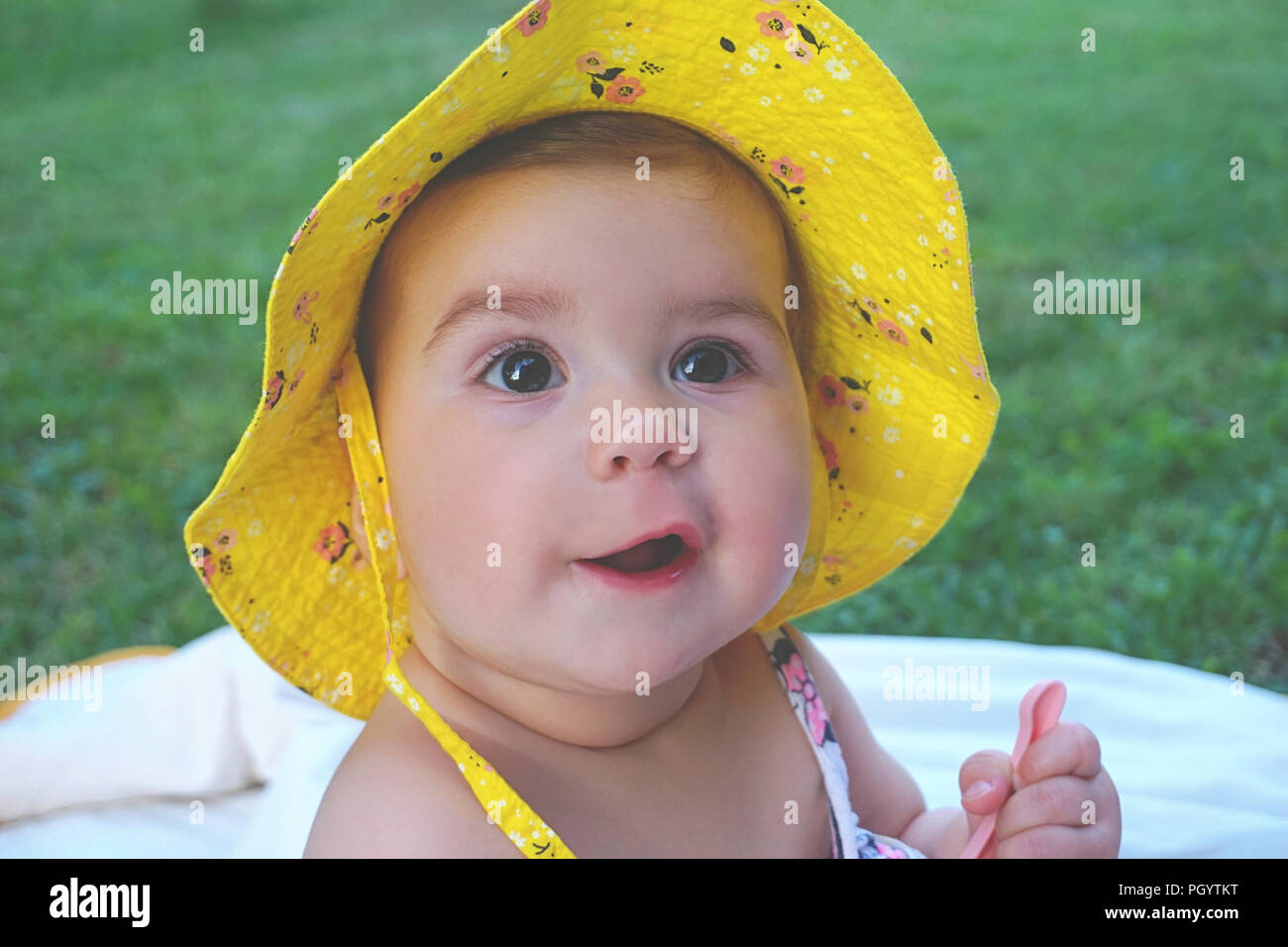 Beautiful happy and healthy baby girl with yellow hat smiling and ...