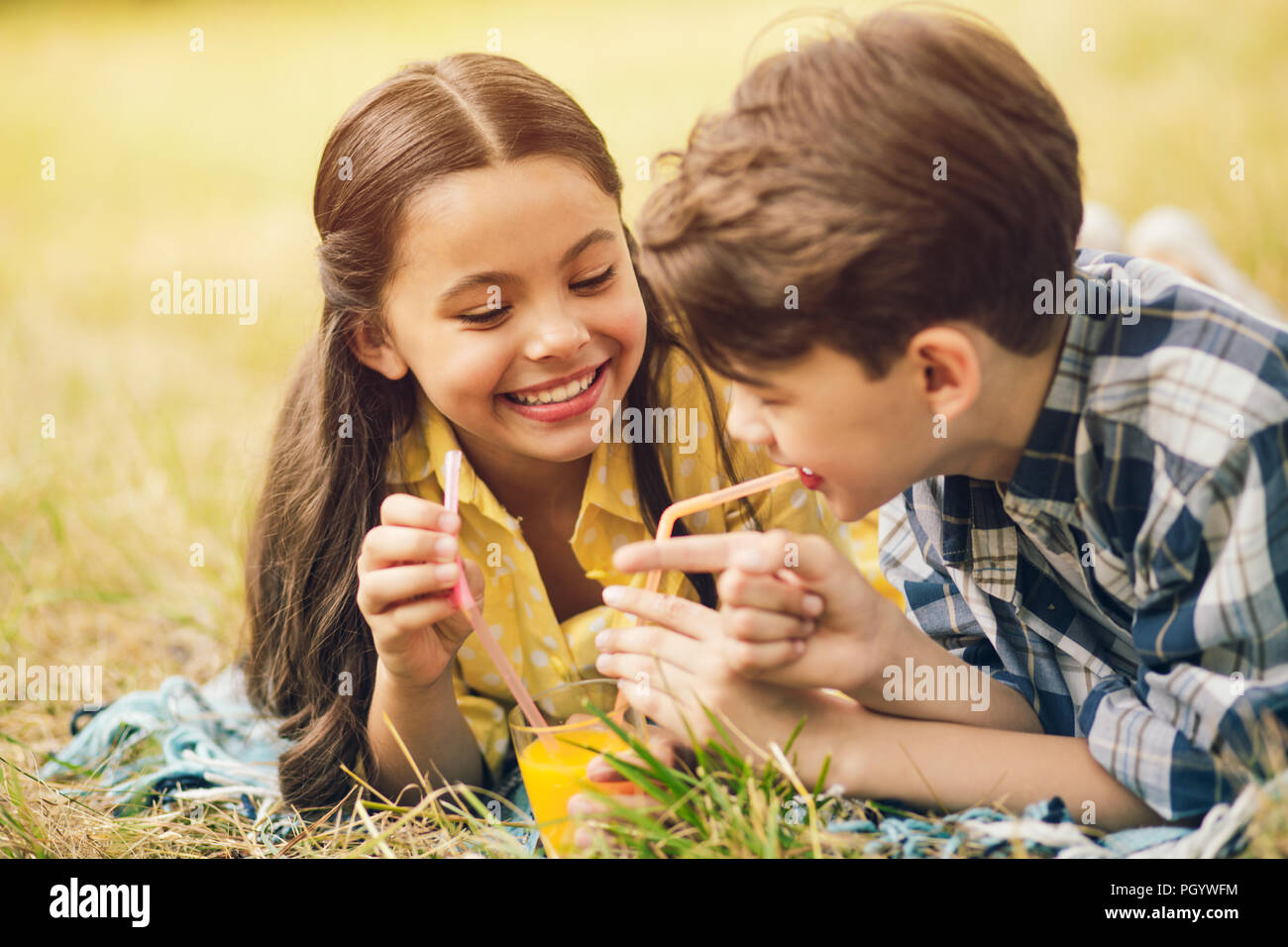 Two kids drinking juice together Stock Photo - Alamy