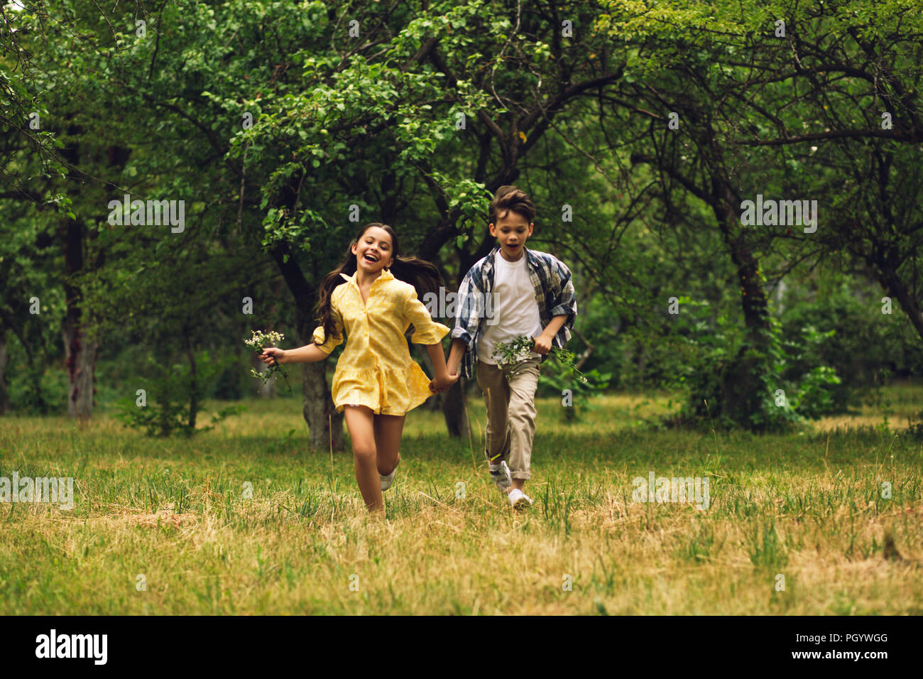 Two kids running in park Stock Photo - Alamy