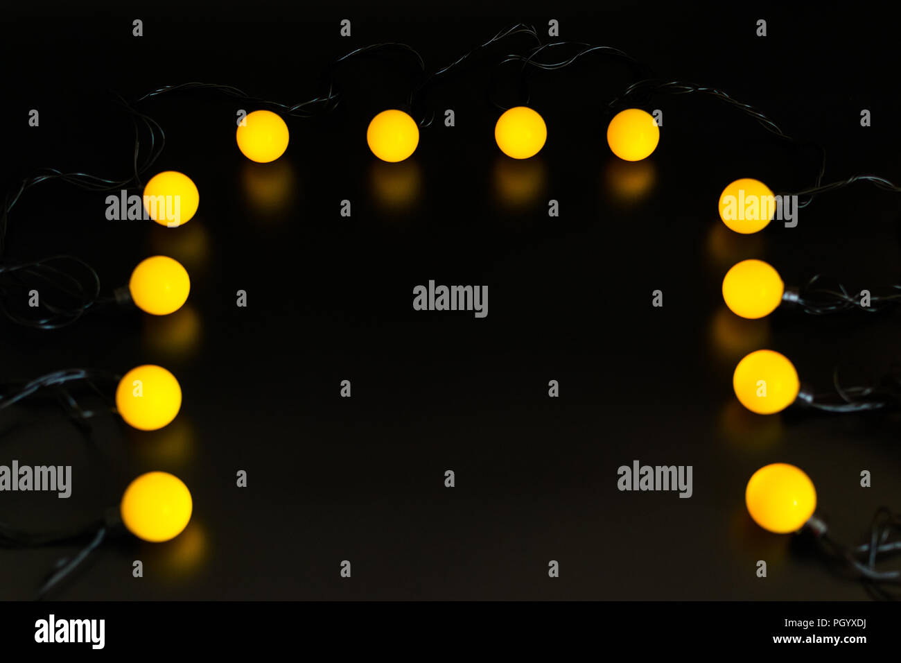 yellow glowing garland neatly straight-lined balls on a black ...