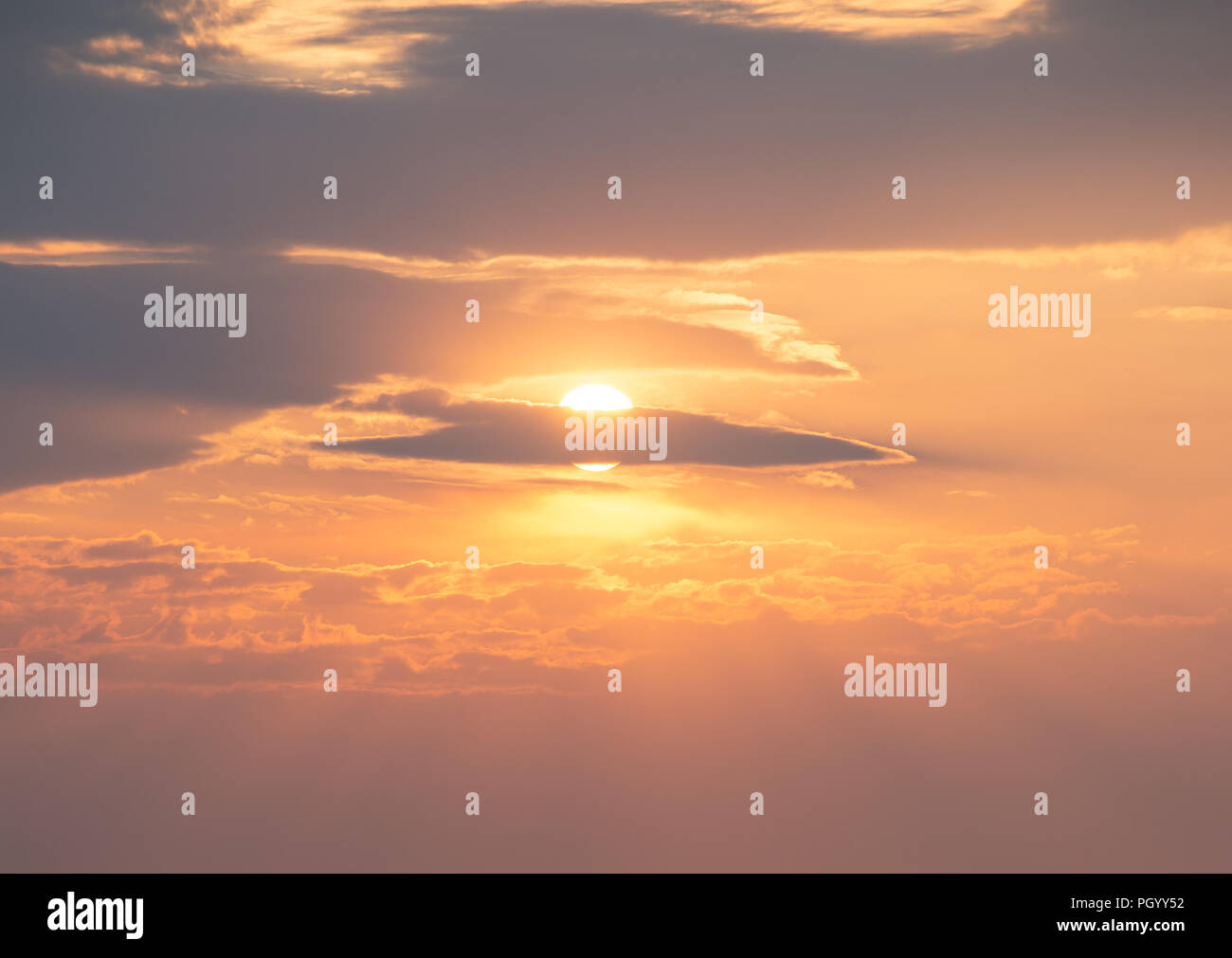 Sunset through clouds Stock Photo - Alamy
