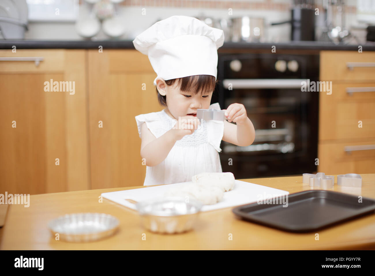 baby girl pretend baking at home Stock Photo - Alamy