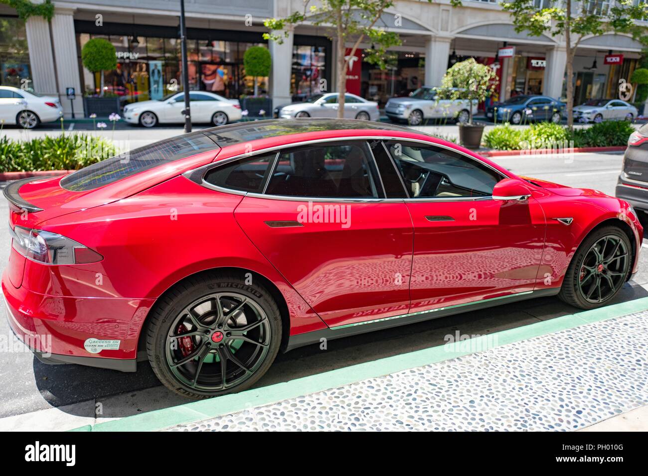 Side view of a bright red Tesla Model 3 automobile from Tesla Motors ...