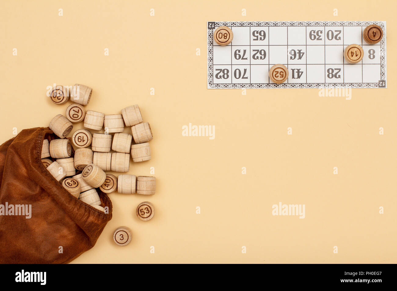 Wooden lotto barrels with cloth bag and game card on beige background ...