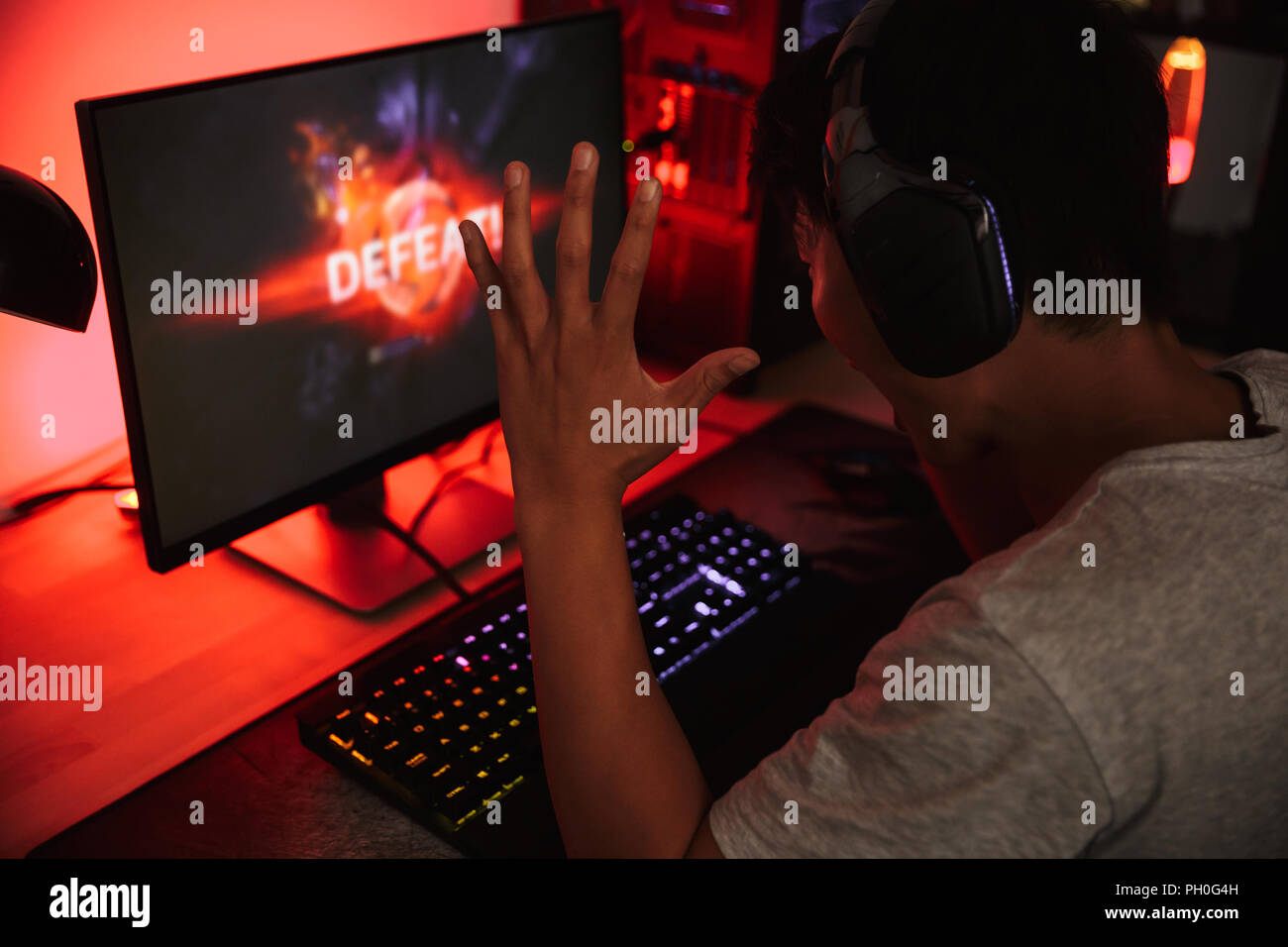 Portrait of upset asian gamer boy losing while playing video games on ...