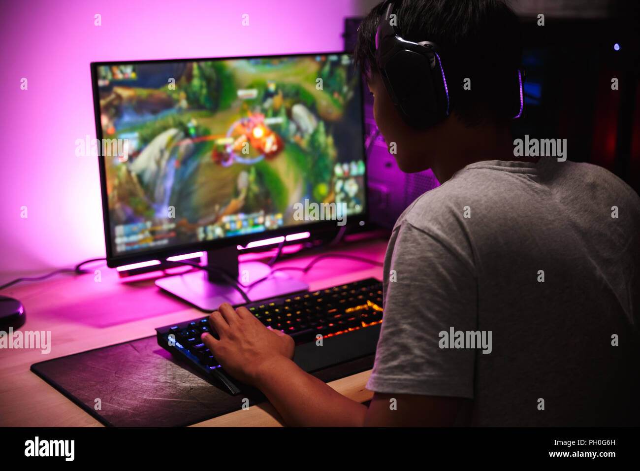 Photo of teenage gamer boy playing video games on computer in dark room ...