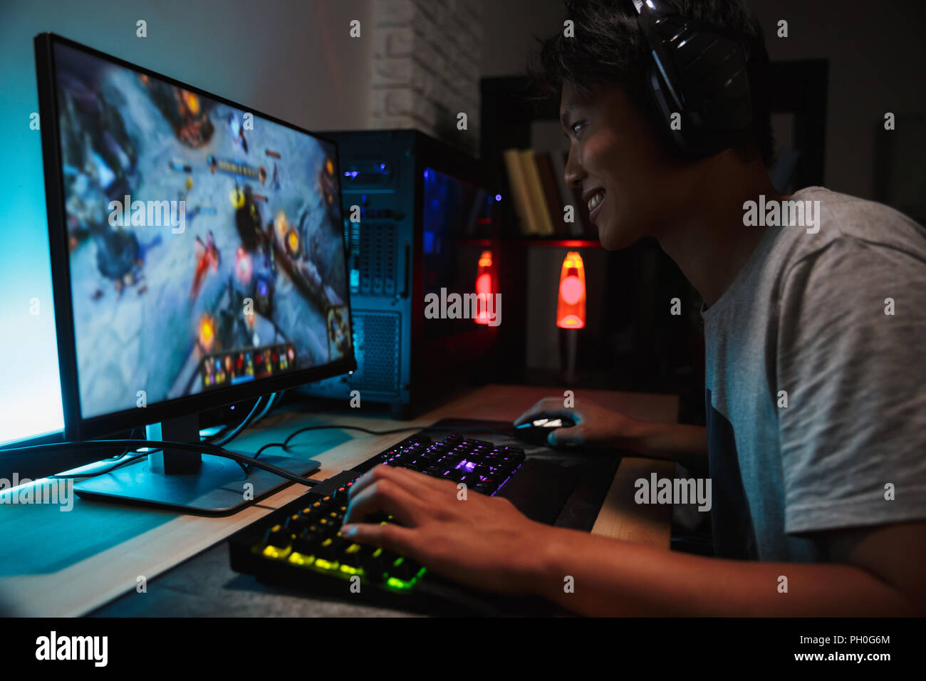 Portrait of smiling asian gamer boy 16-18 playing video games on ...