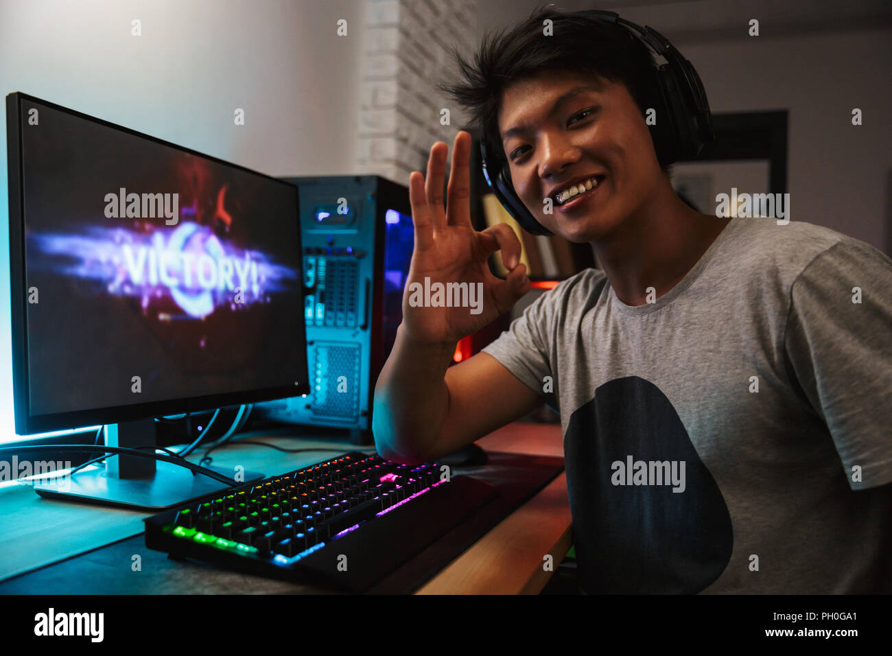 Excited smiling gamer boy rejoicing victory while playing video games ...