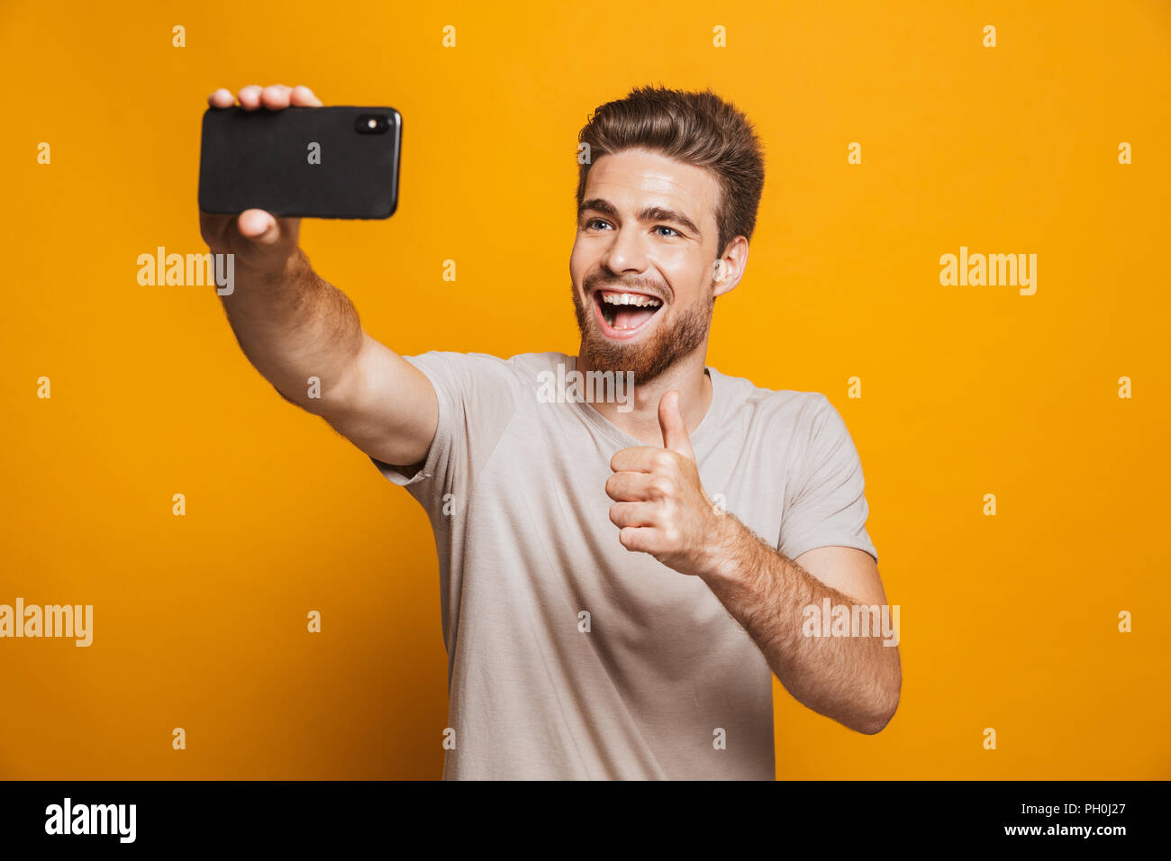 Image of handsome happy man standing isolated over yellow wall ...