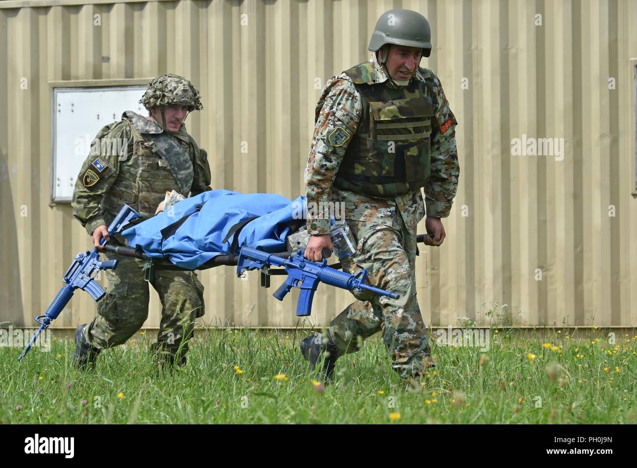 From left to right, a Kosovar and a Macedonian soldier evacuate a ...