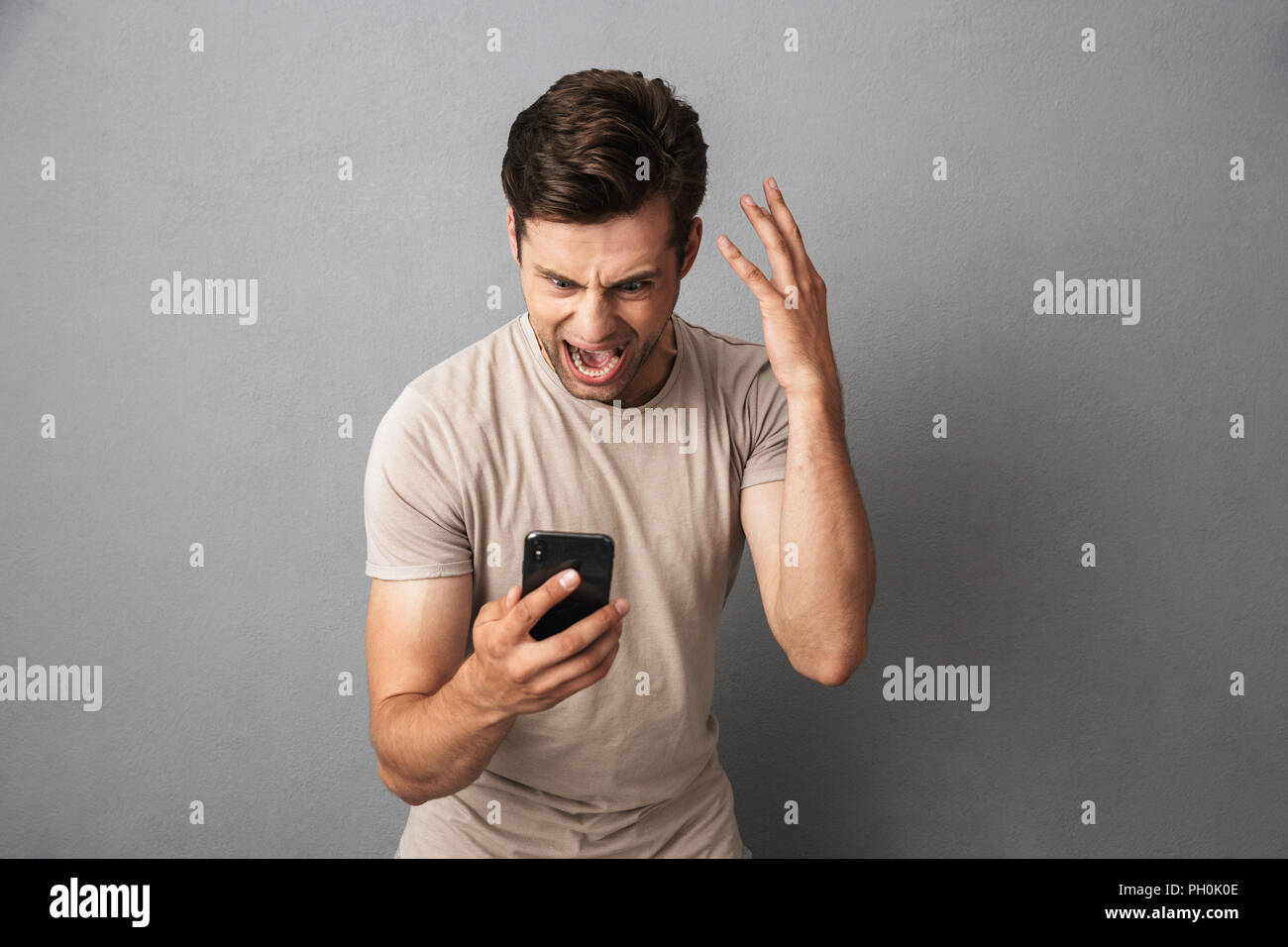 Nervous upset guy 20s in t-shirt shouting in anger while looking at ...