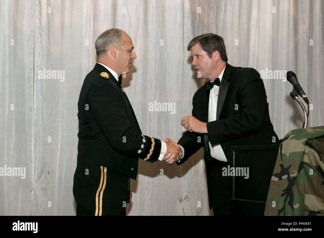 Retired Army Col. Sam Torrey shakes hands with Army Gen. Gus Perna ...