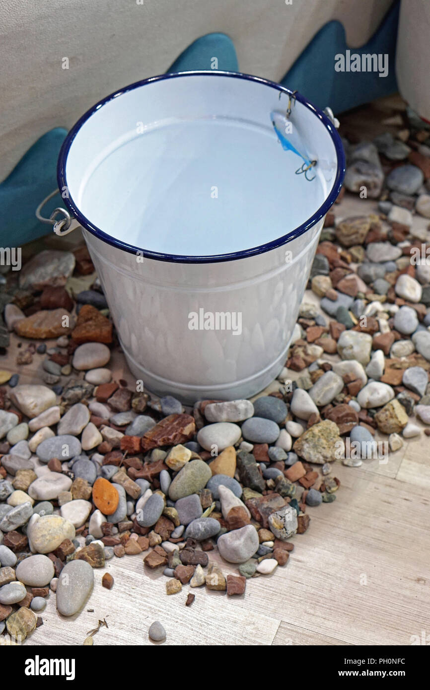 Retro style metal bucket at rocks pebbles Stock Photo - Alamy