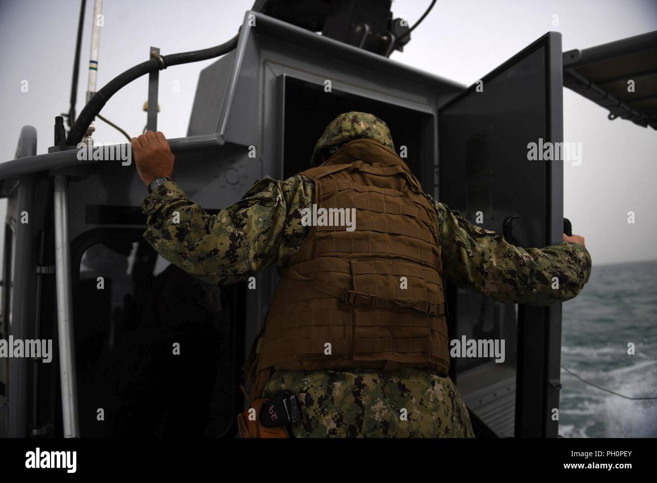 A U.S. Navy member assigned to Coastal Riverine Squadron 10 checks the ...