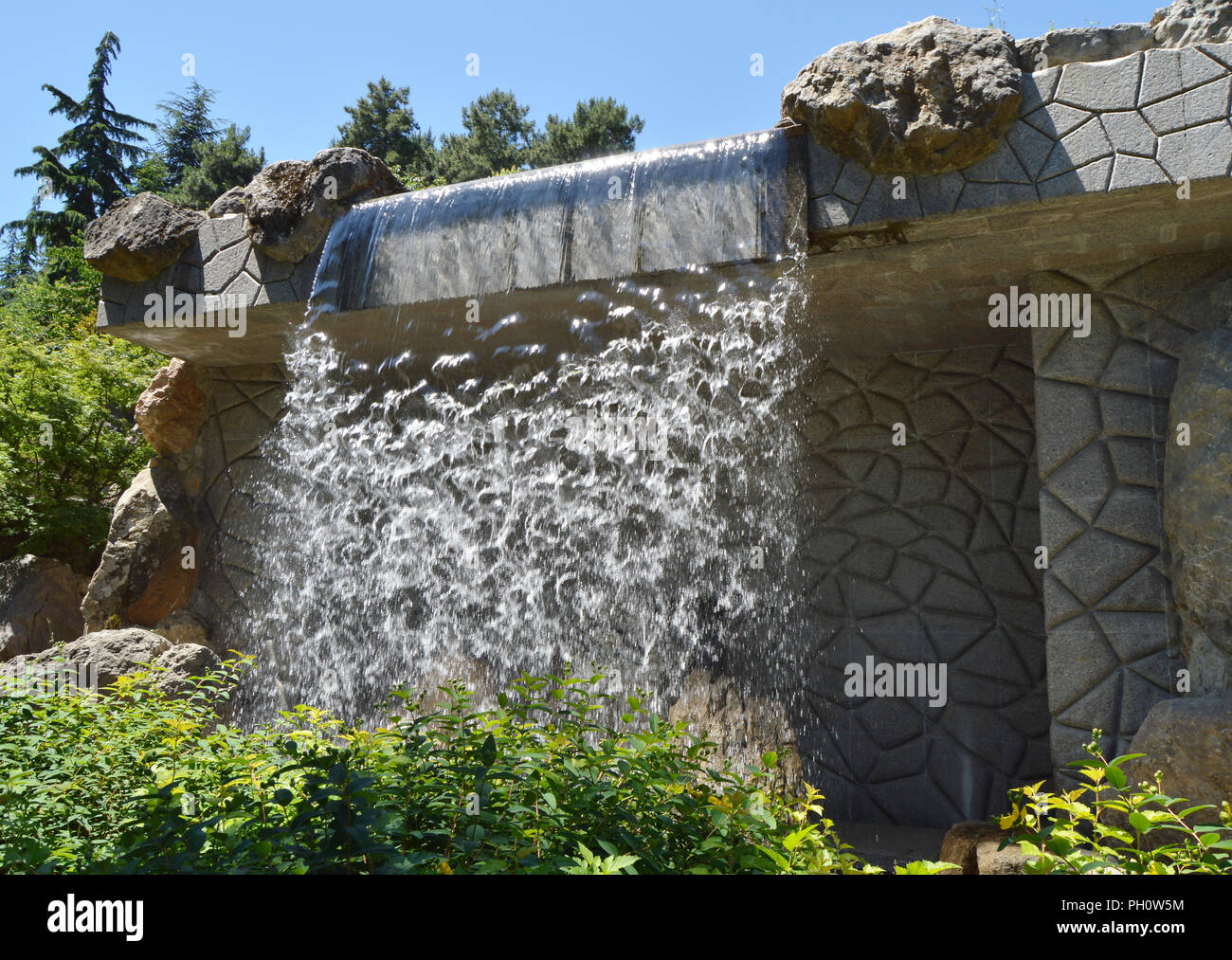 Artificial waterfall with water jets, modern stone structure, beautiful ...