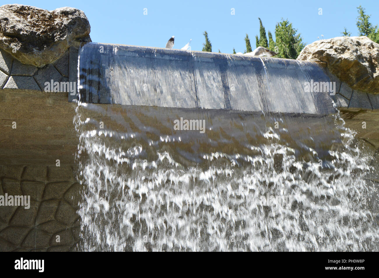 Artificial waterfall with water jets, modern stone structure, beautiful ...